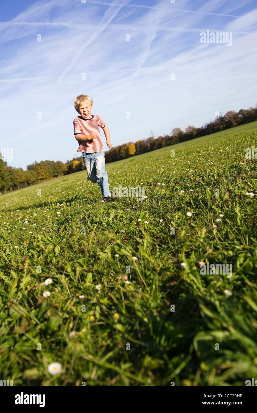 Little boy (4-5) running across meadow Stock Photo - Alamy