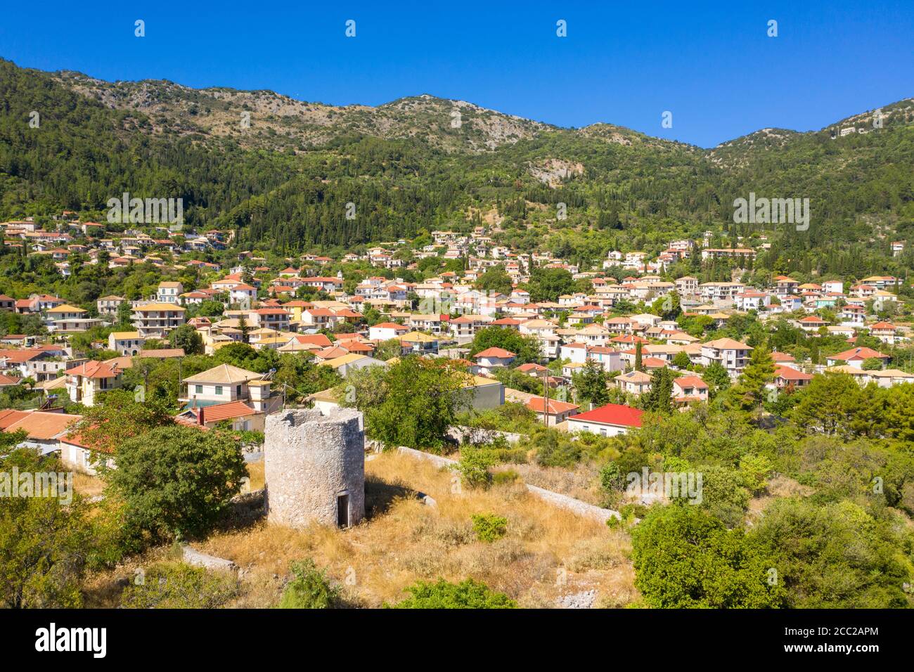 A ruined windmill with buildings behind at Karya, a traditional ...