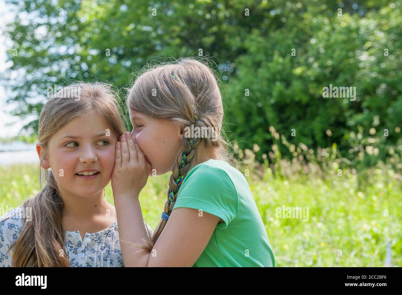Girl whispering in another girls ear hi-res stock photography and ...