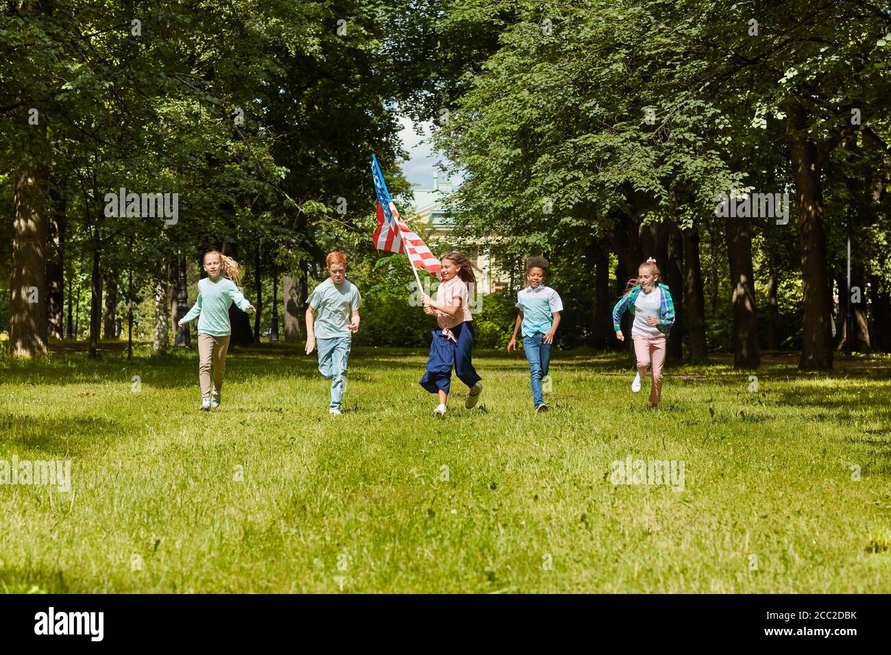 Wide angle view at multi-ethnic group of kids running towards camera ...