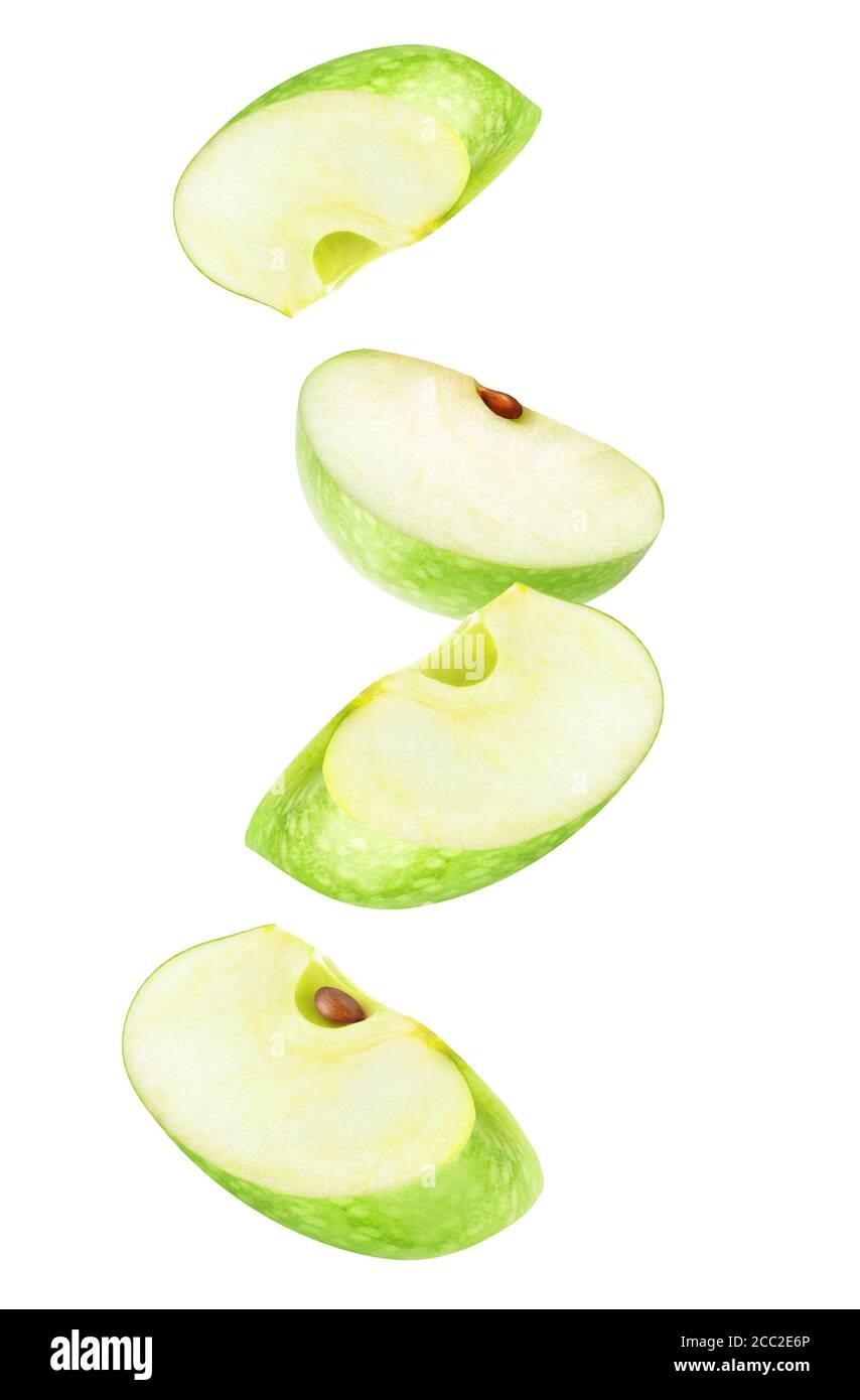 Isolated apple wedges in the air. Four falling pieces of green apple ...