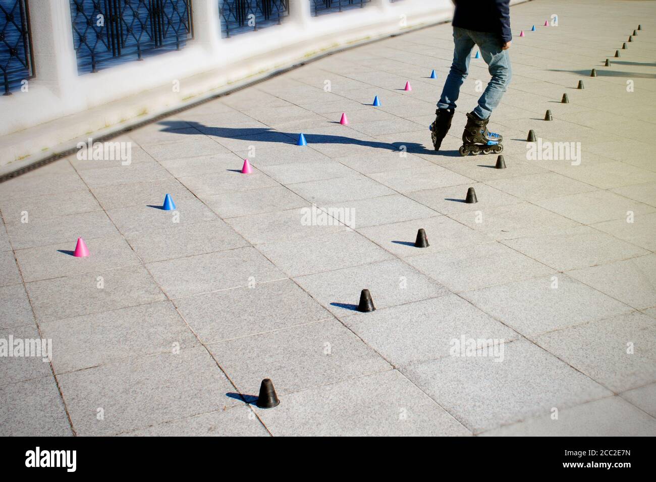 Roller skater practicing slalom along a line of cones Stock Photo - Alamy