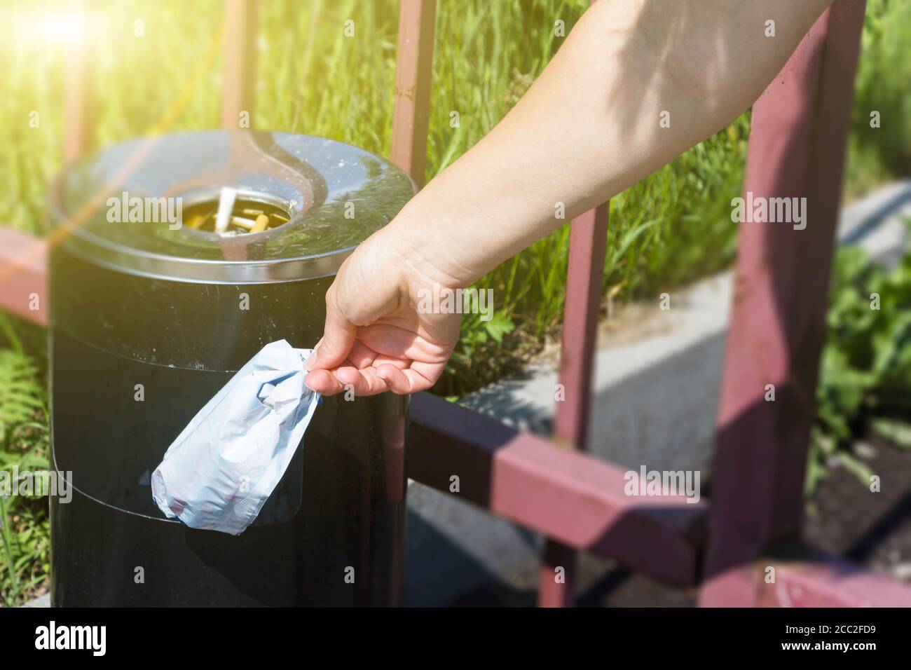Close - up of cropped portrait of someone throwing trash in the trash ...