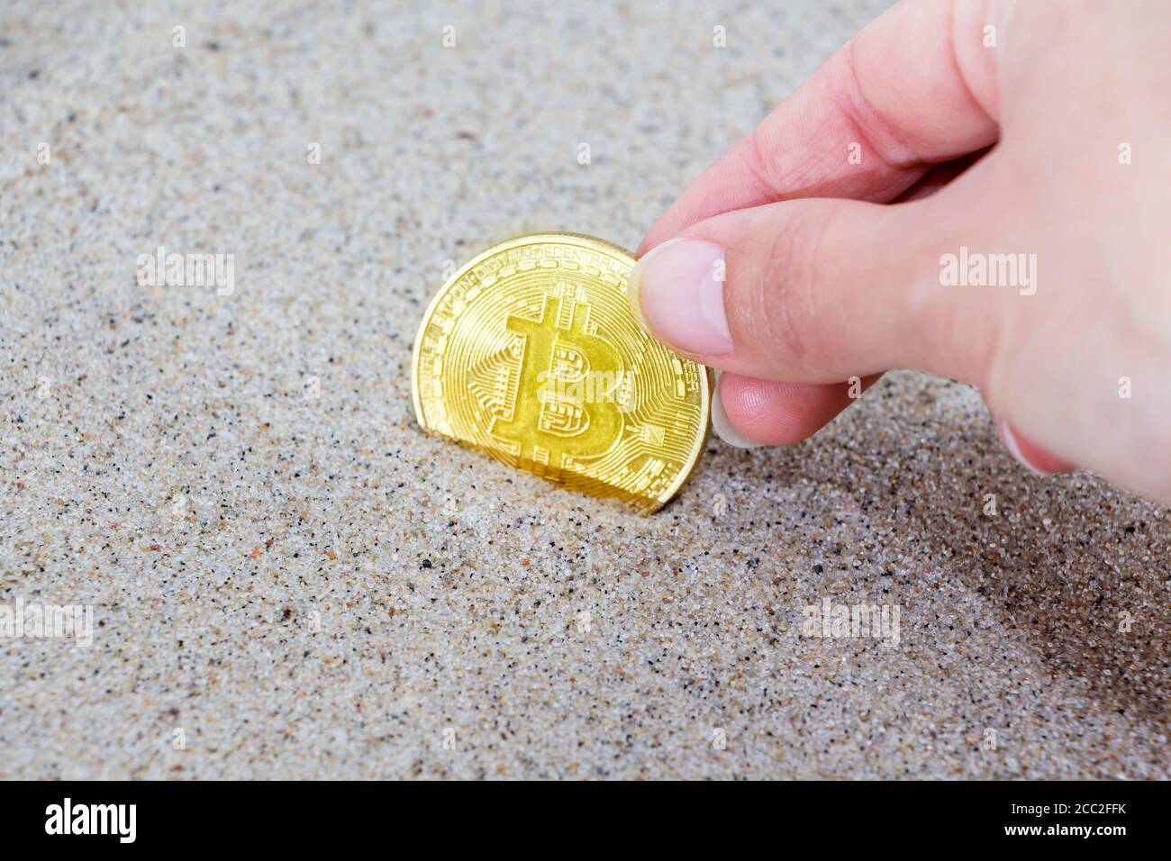 coin bitcoin buried in the sand. Bitcoin is the most popular ...