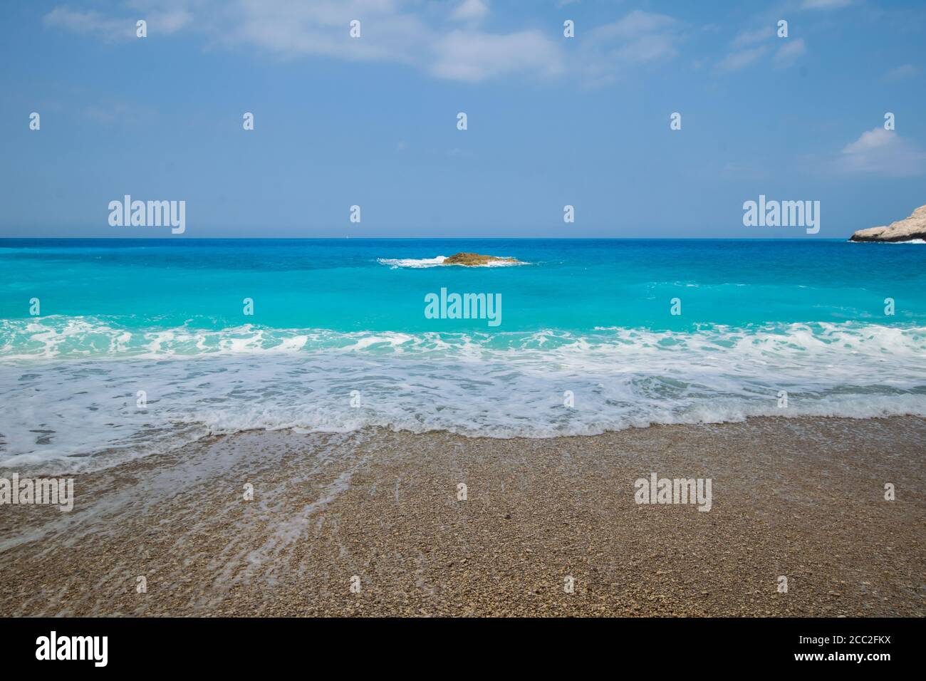 Foam covering the pebbles after big wave crushed on the beach with ...