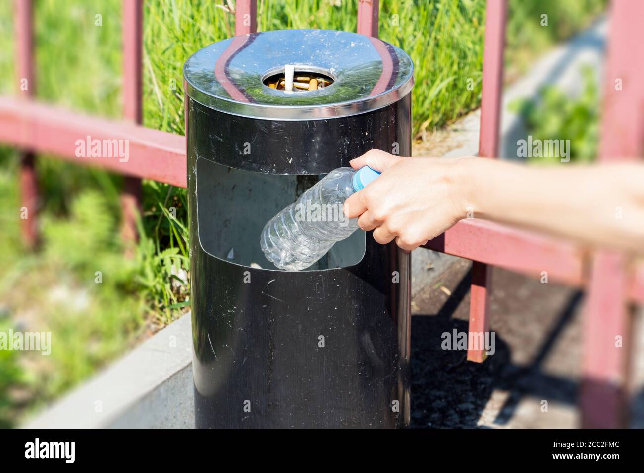 Close - up of cropped portrait of someone throwing trash in the trash ...