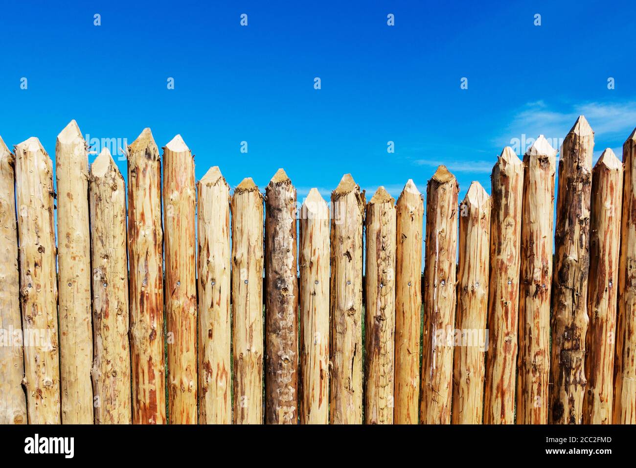 Wooden fence made of sharpened planed logs Stock Photo - Alamy