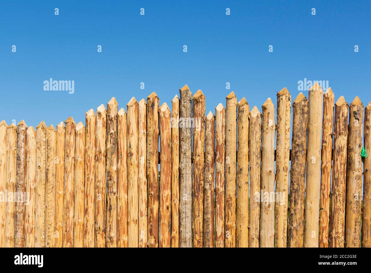 Wooden fence made of sharpened planed logs Stock Photo - Alamy