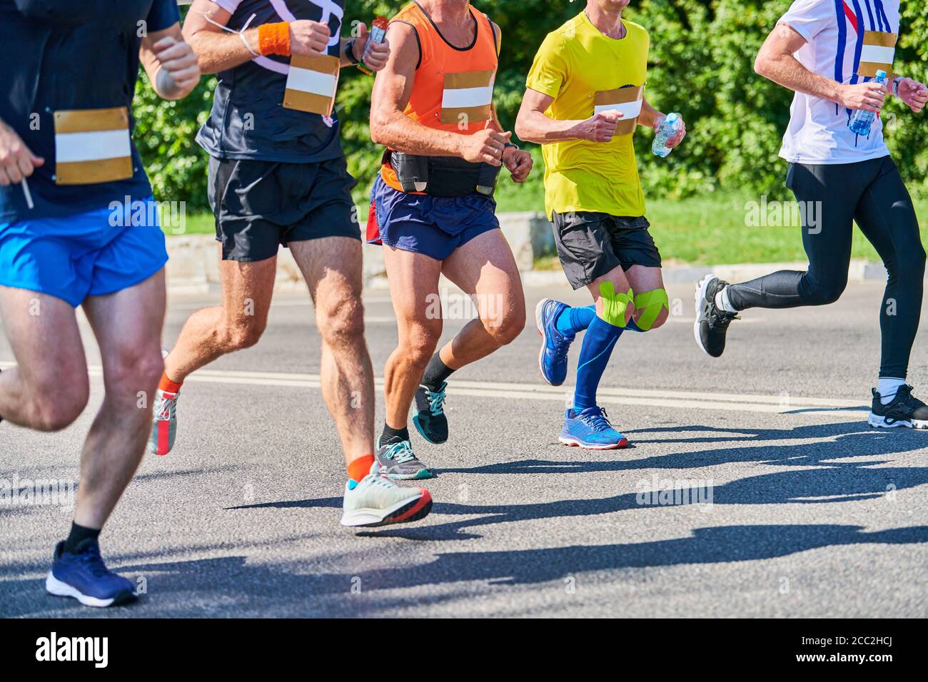 Marathon runners on city road. Running competition. Street sprinting ...