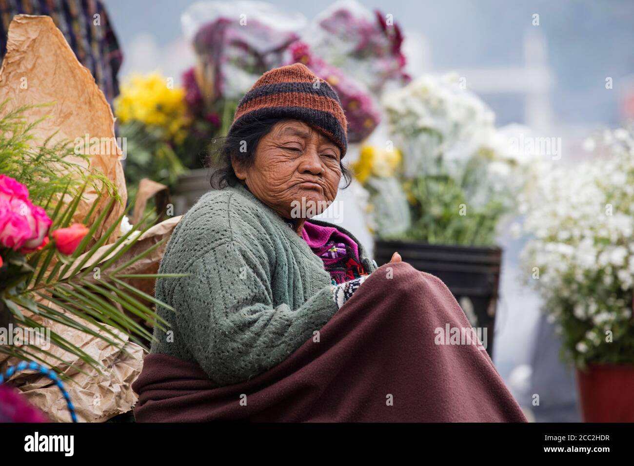 Old local Mayan K'iche woman selling flowers on market day in the town ...