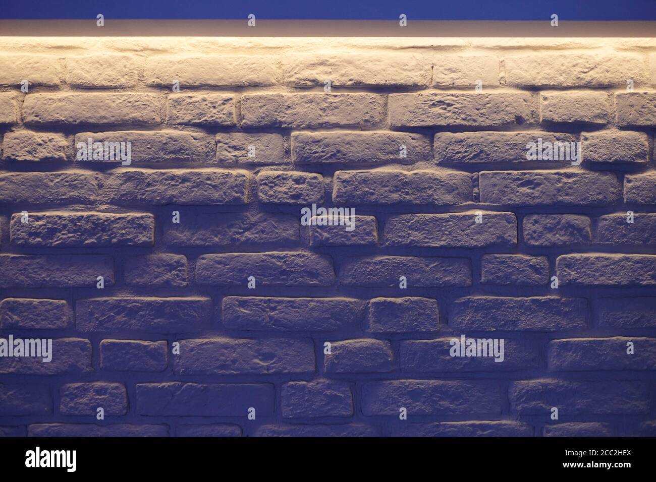 Brick wall indigo lighting. White wall blue glow in modern vintage loft ...