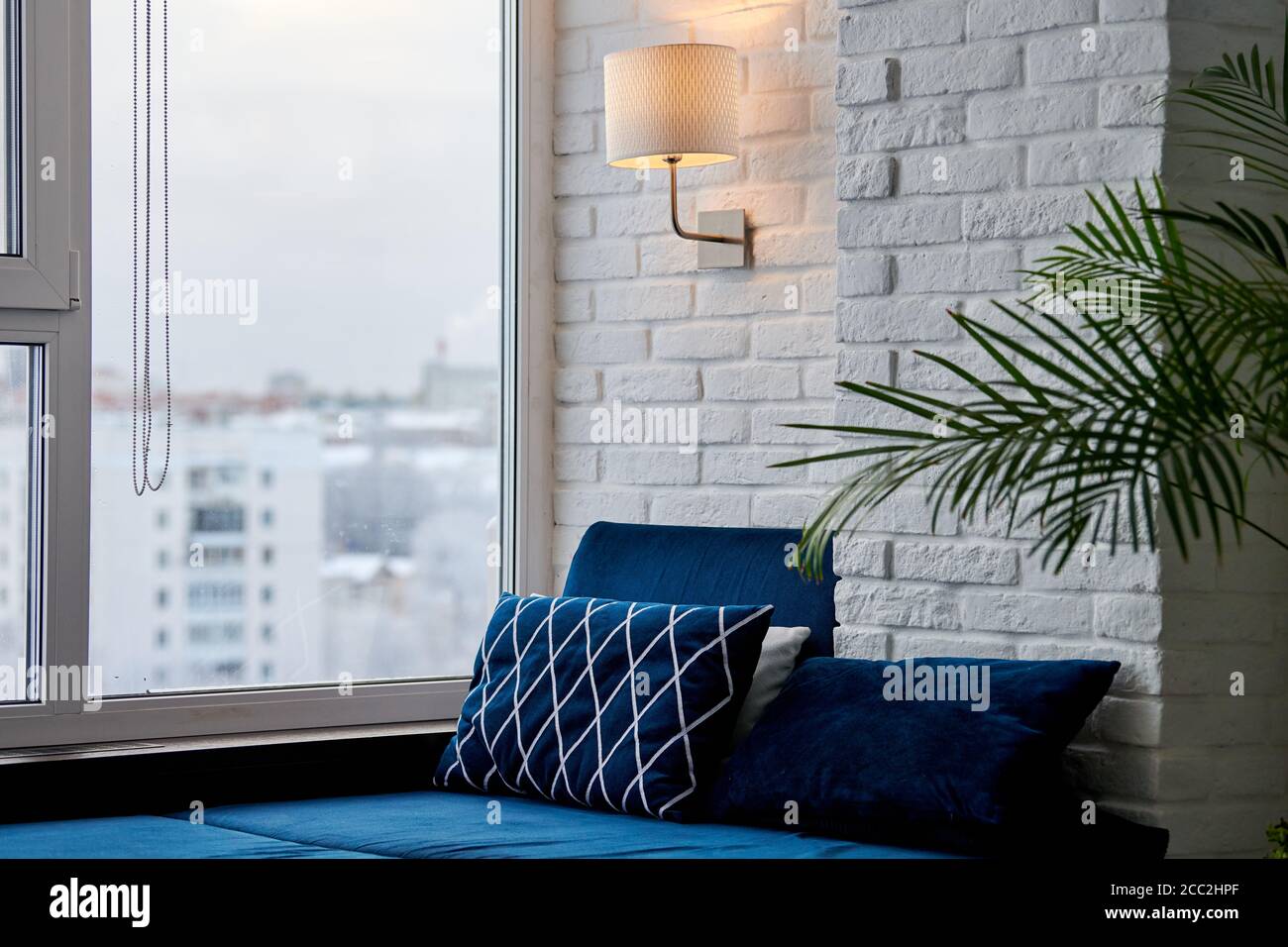 Modern loft apartment with sofa and window view on cityscape. Stylish ...