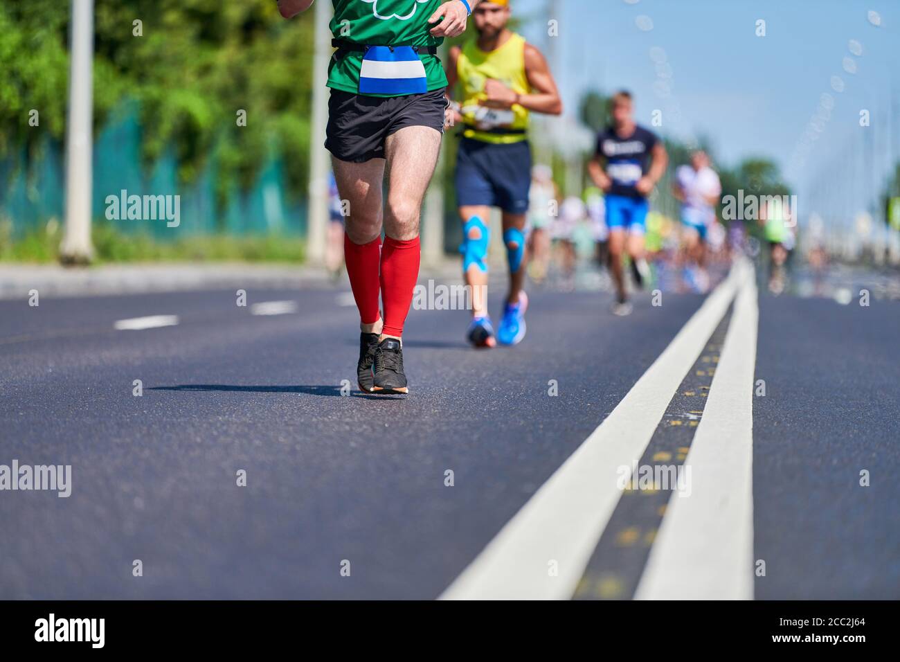 Marathon runners on city road. Running competition. Street sprinting ...