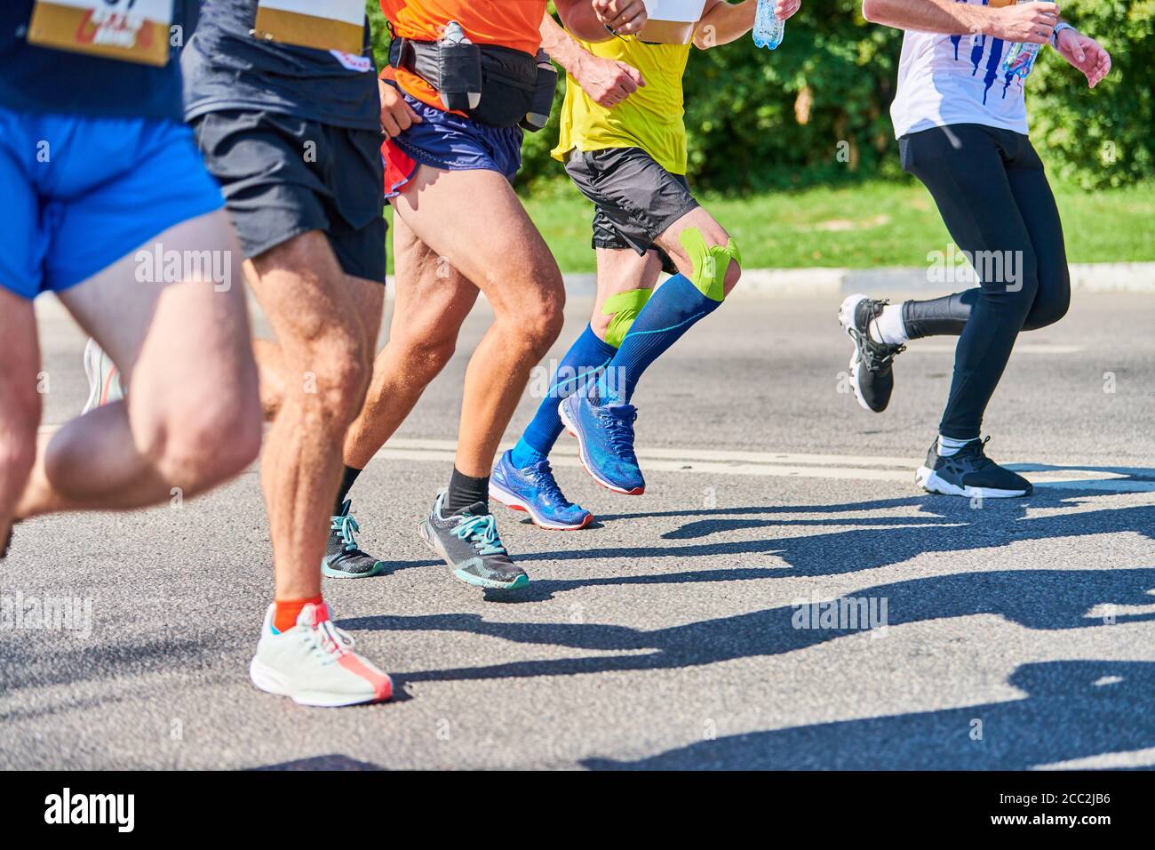 Marathon runners on city road. Running competition. Street sprinting ...