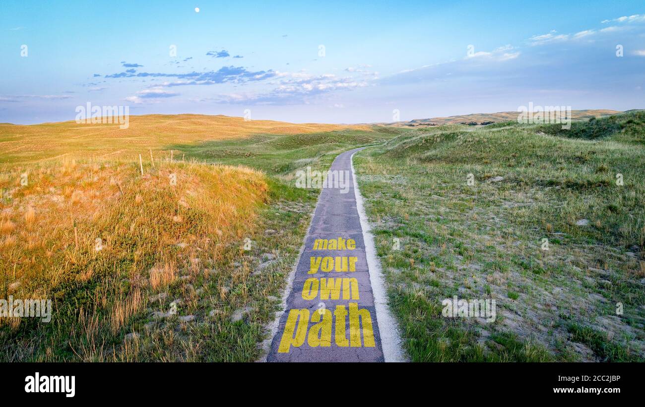 make your own path inspirational text on a narrow, one lane road across ...