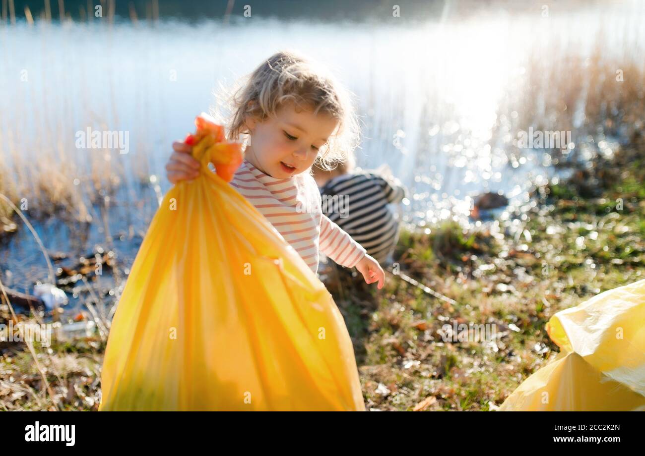 Small children collecting rubbish outdoors in nature, plogging concept ...