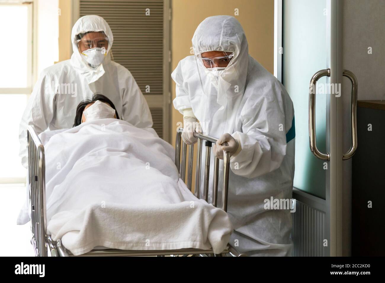 asian male nurse and doctor wearing ppe suit and face mask pushing ...
