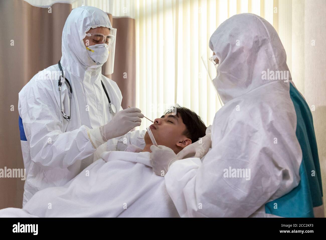 male nurse and doctor wearing ppe suit and facemask perform Coronavirus ...