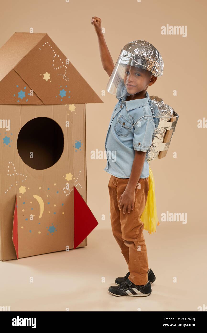 Vertical full length portrait of cute African-American boy playing ...