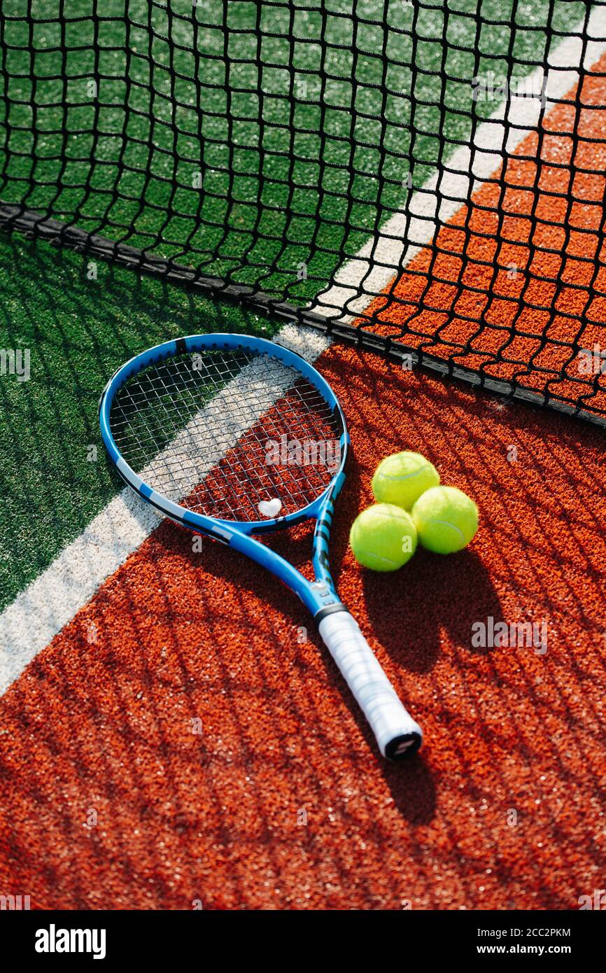 Tennis racket lying on the line between inner ond outer court next to ...