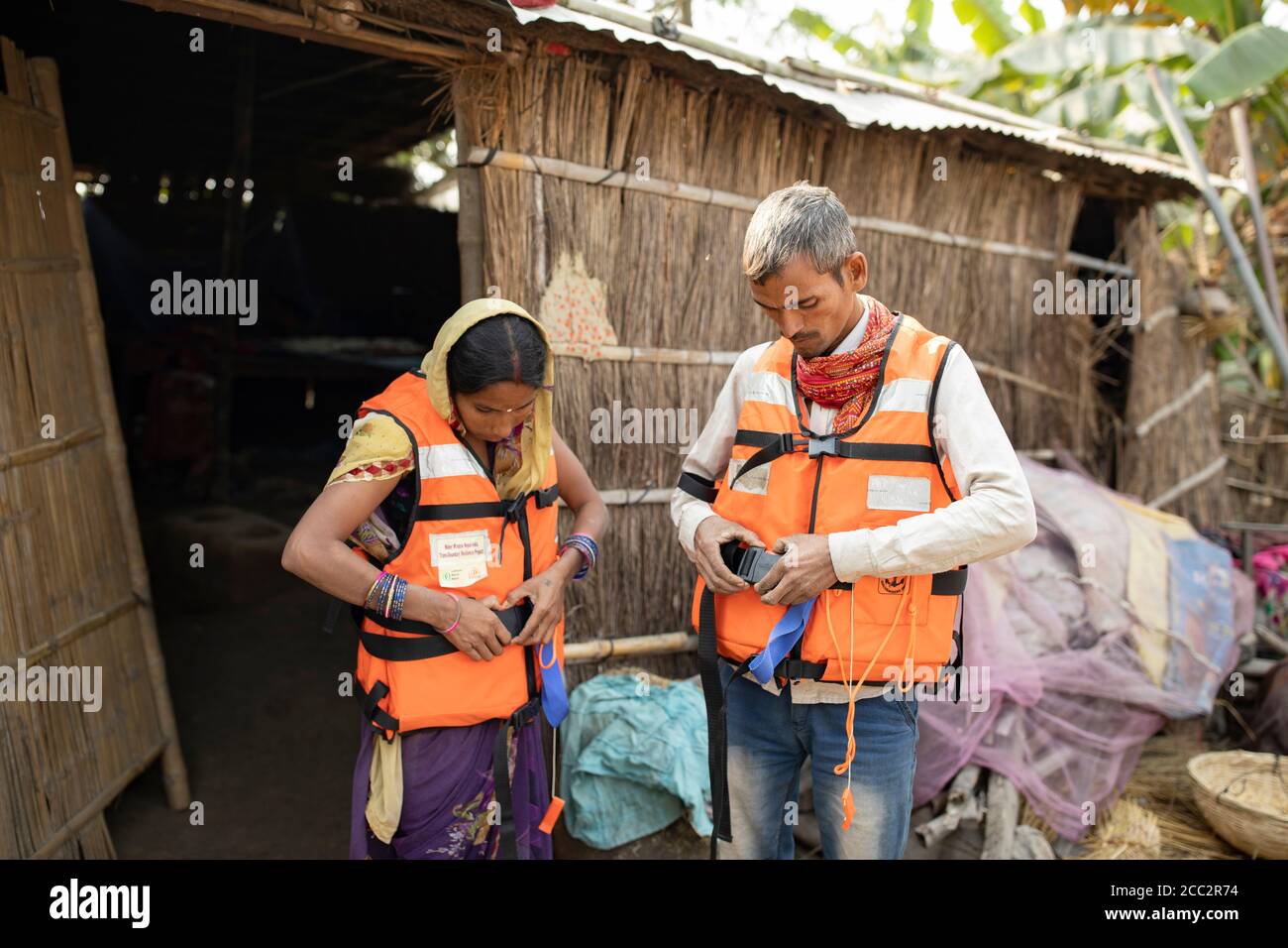 A woman and her husband don life jackets in a flood-preparation drill ...