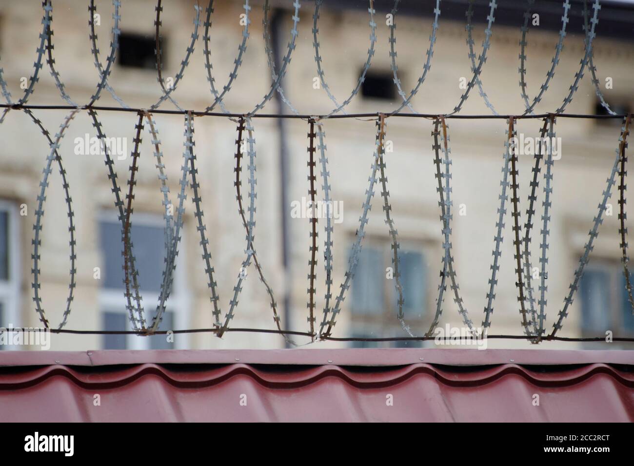 Barbed wire and windows of a building in the background. Close up Stock ...