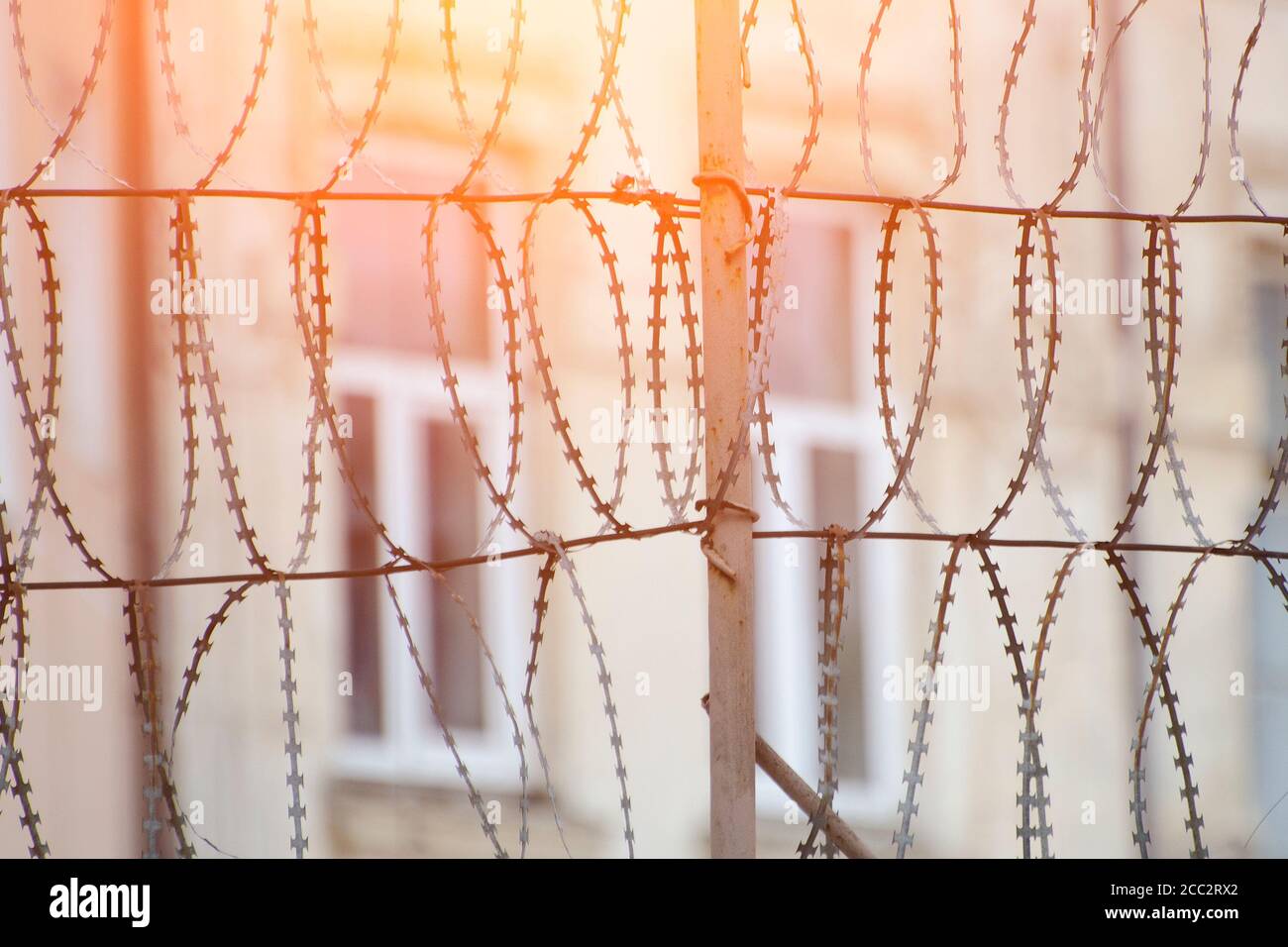 Barbed wire and windows of a building in the background. Close up Stock ...