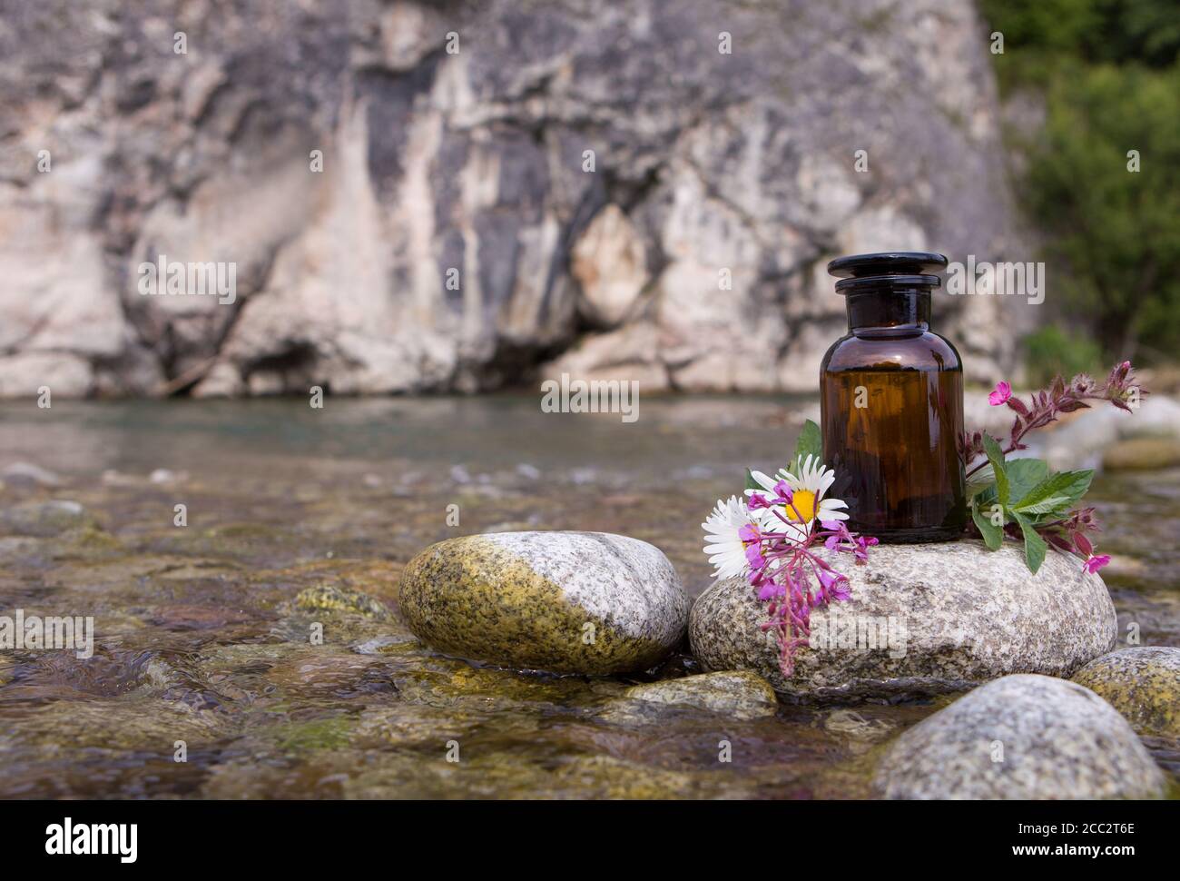 A brown magic potion bottle on a stone. Herbal medicine from dried ...