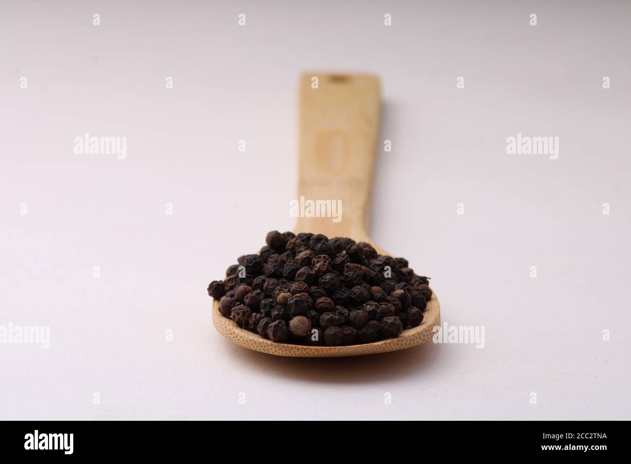 black pepper in wooden spoon isolated on white background Stock Photo ...