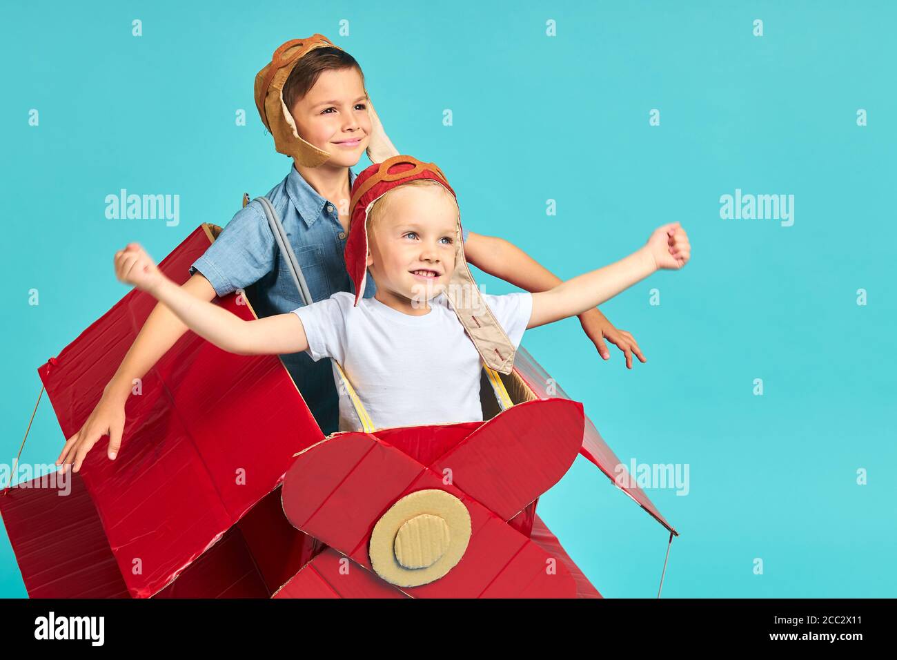 Two little friends flying on toy red airplane, blue sky. Portrait Stock ...