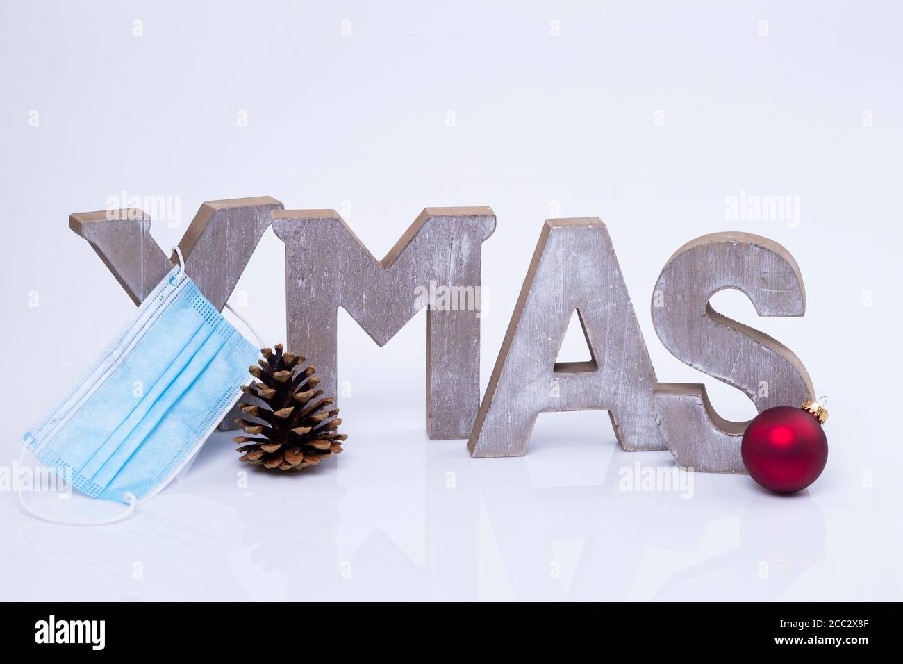 The photo shows the word X-Mas written with wooden letters with ...