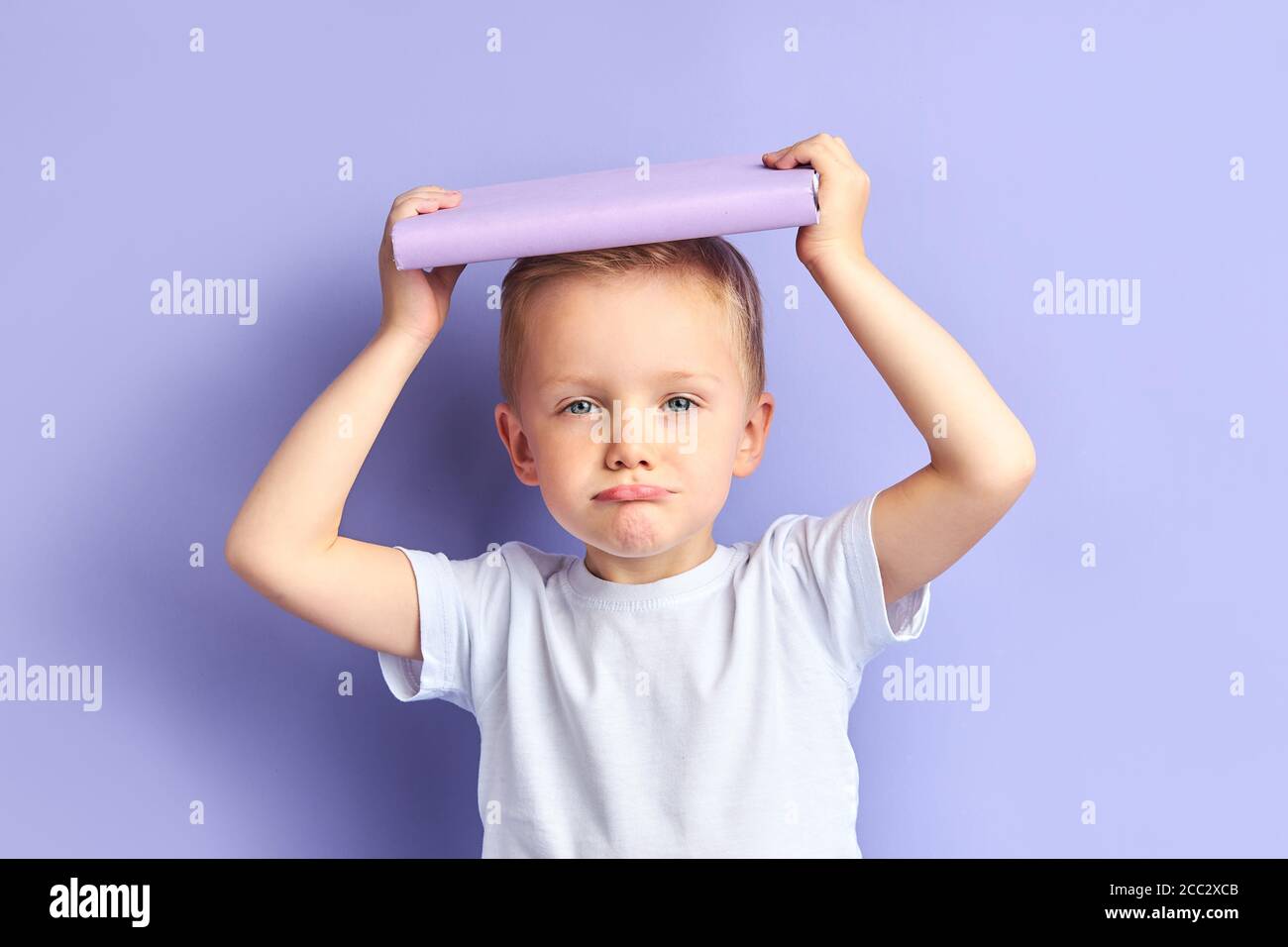 Sad face of child. Caucasian little boy tired of reading book, hold ...