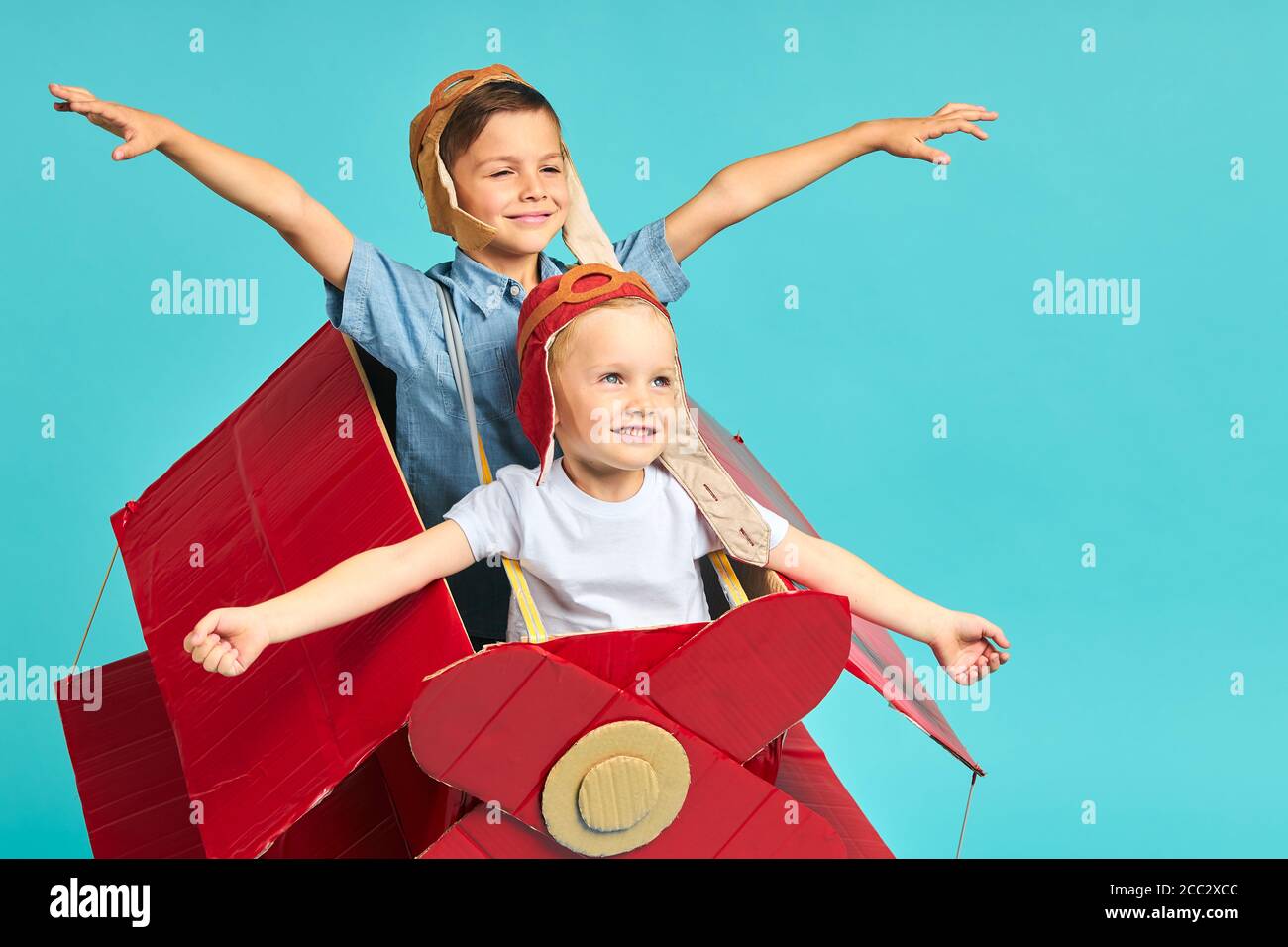 Two little friends flying on toy red airplane, blue sky. Portrait Stock ...