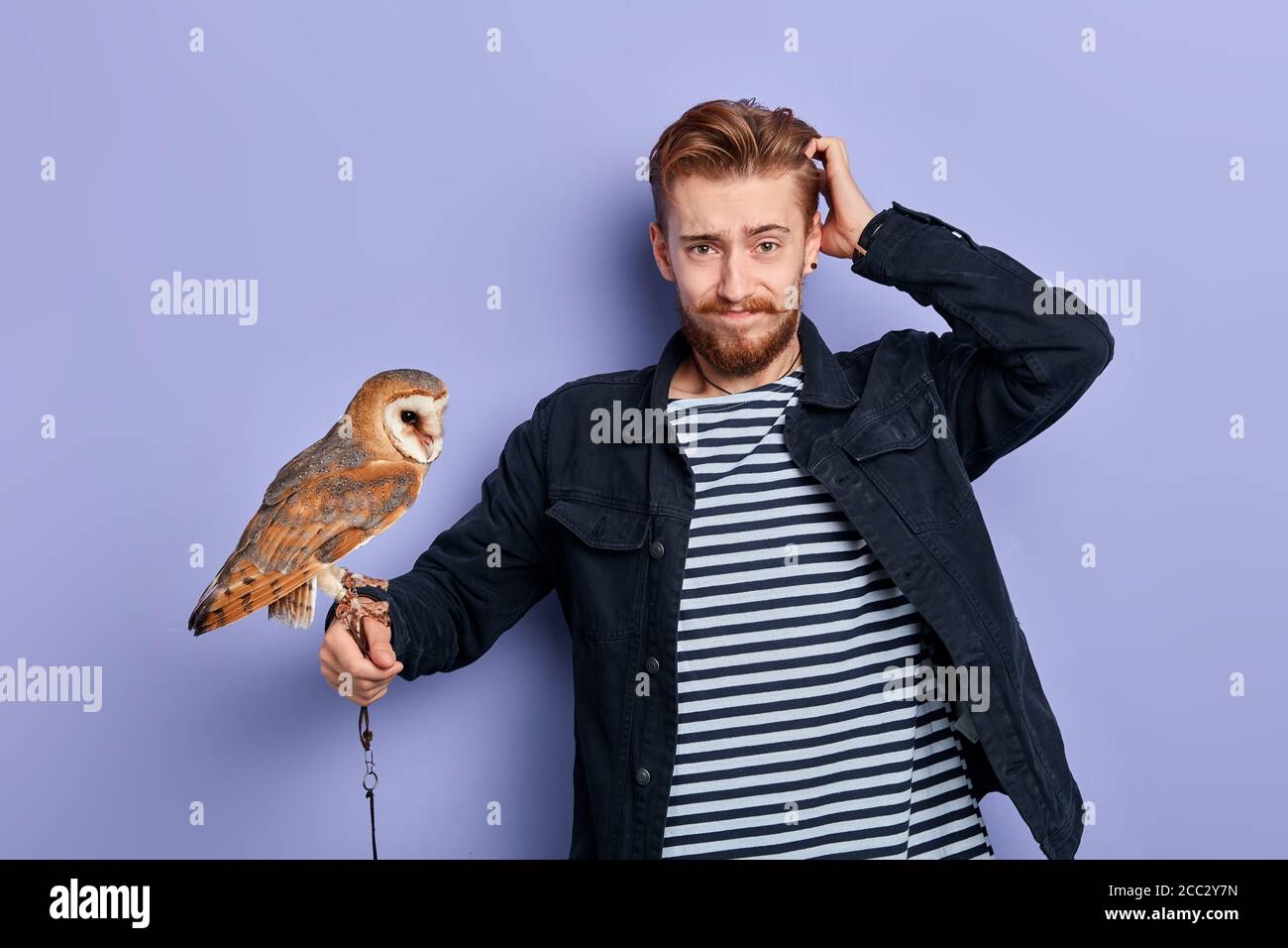 young man touching his head , hesitating how to take care of bird. idea ...