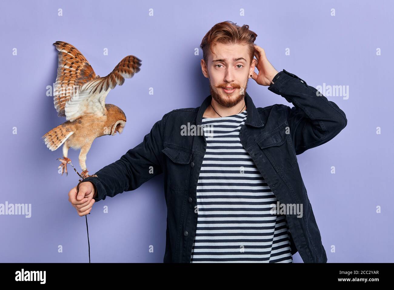 puzzled handsome young bearded ginger man scratching his head while ...