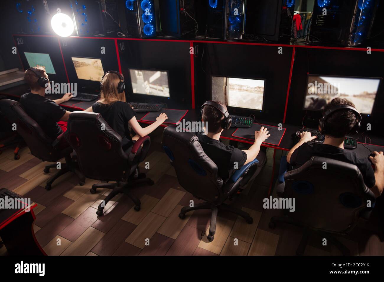 group of concentrated guys in headphones enjoying online video game on ...