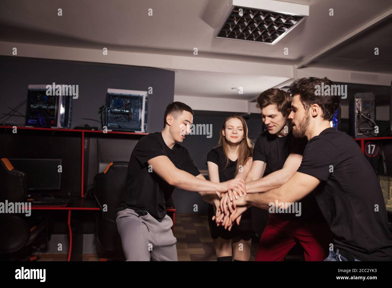 Cheerful excited surprised handsome group of gamers guys and one girl ...