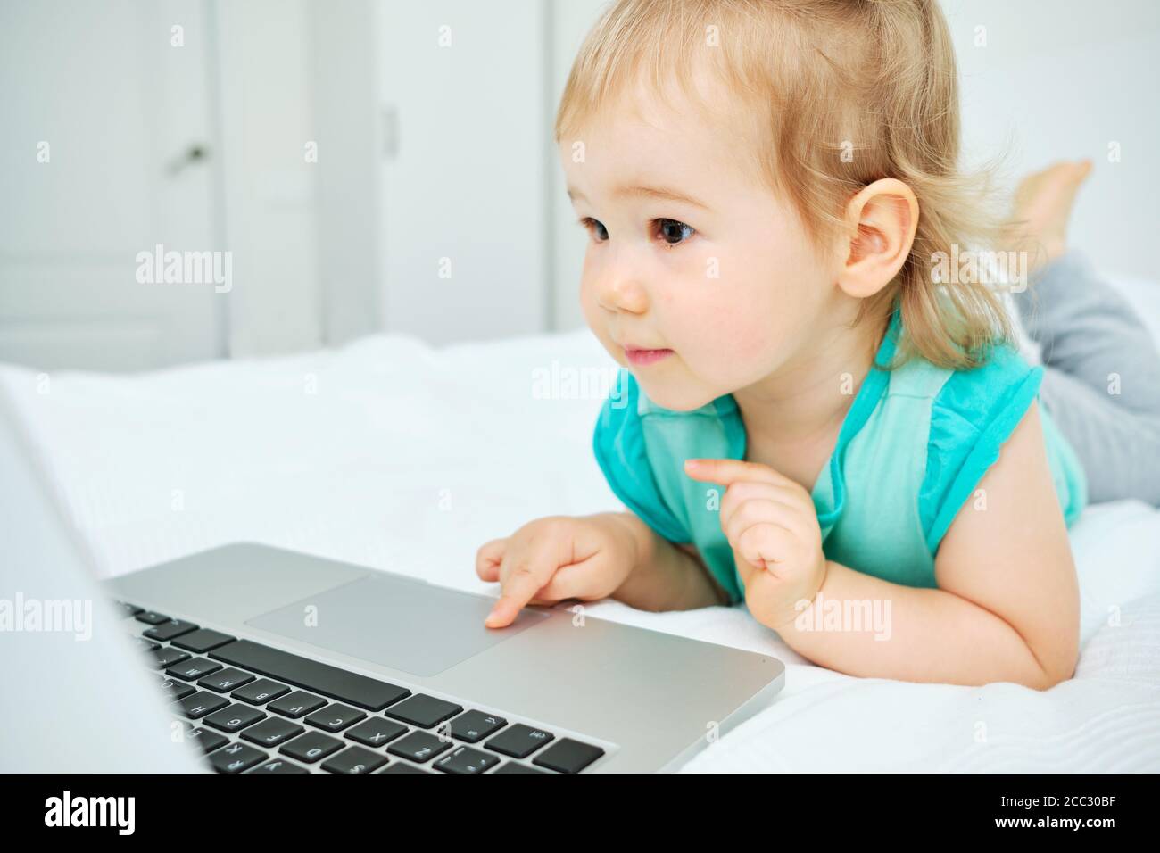 Happy and smiling kid uses his laptop lying on the bed Stock Photo - Alamy