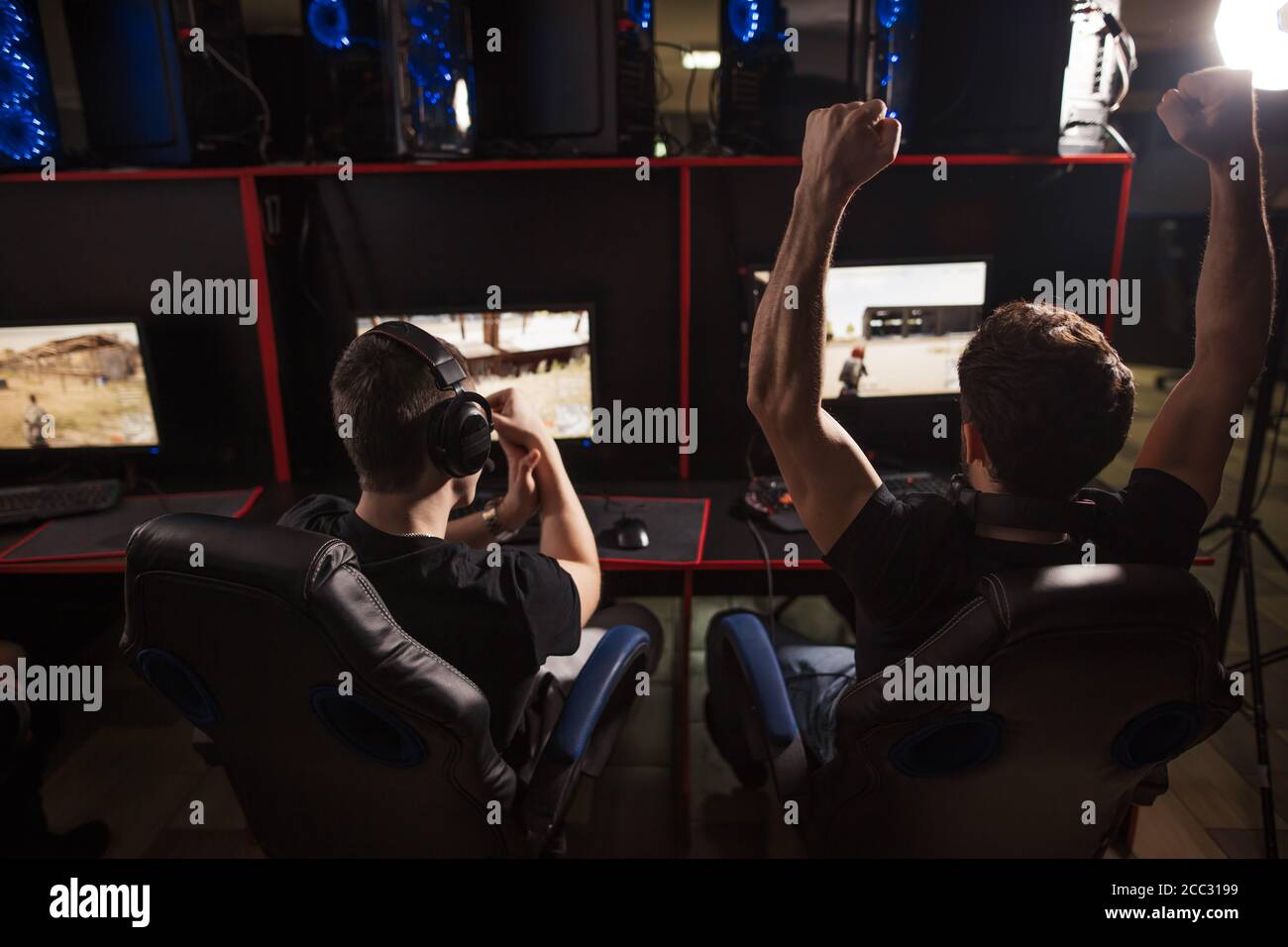 group of concentrated guys in headphones enjoying online video game on ...