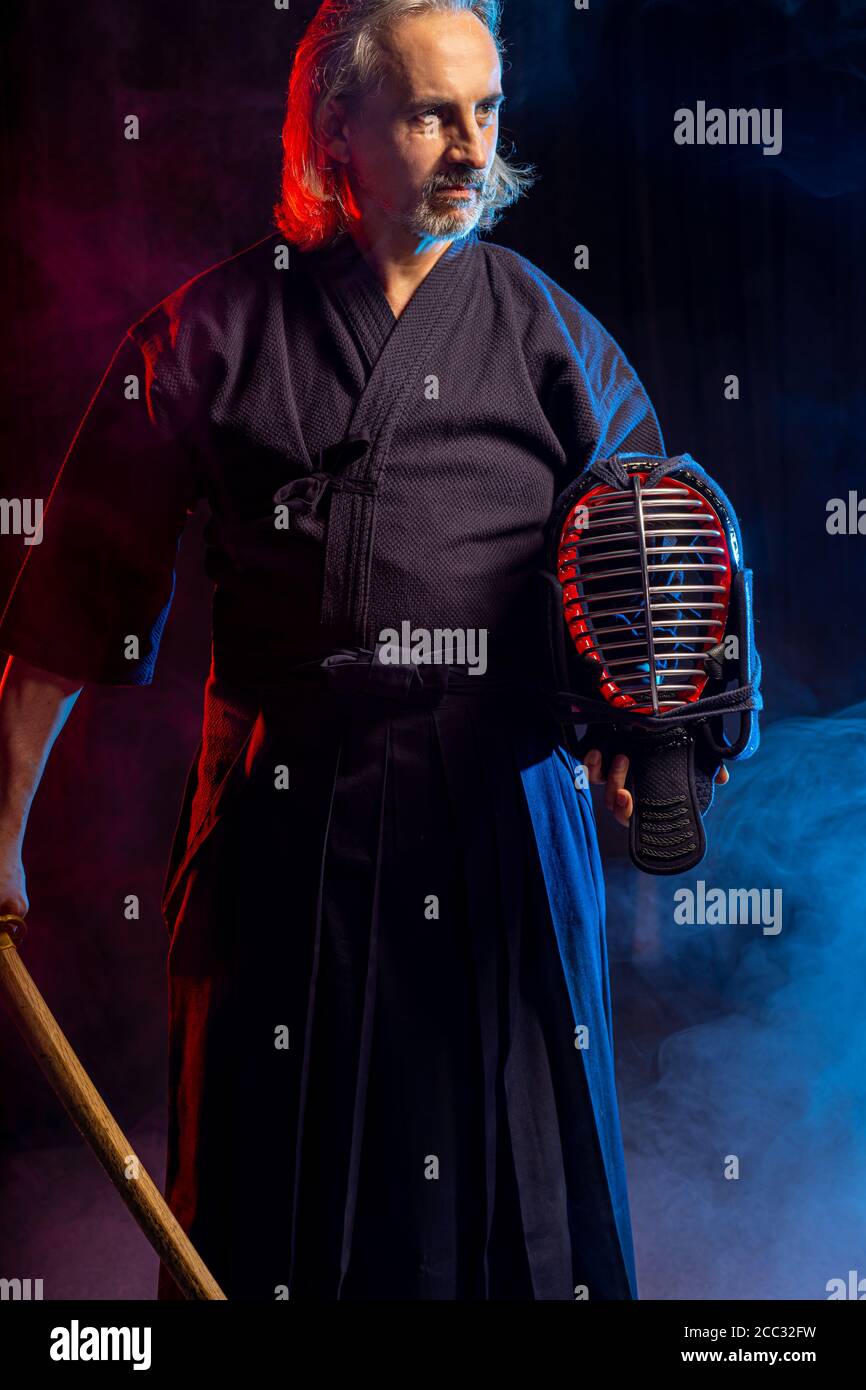 confident caucasian kendo warrior in traditional outfit use bamboo ...