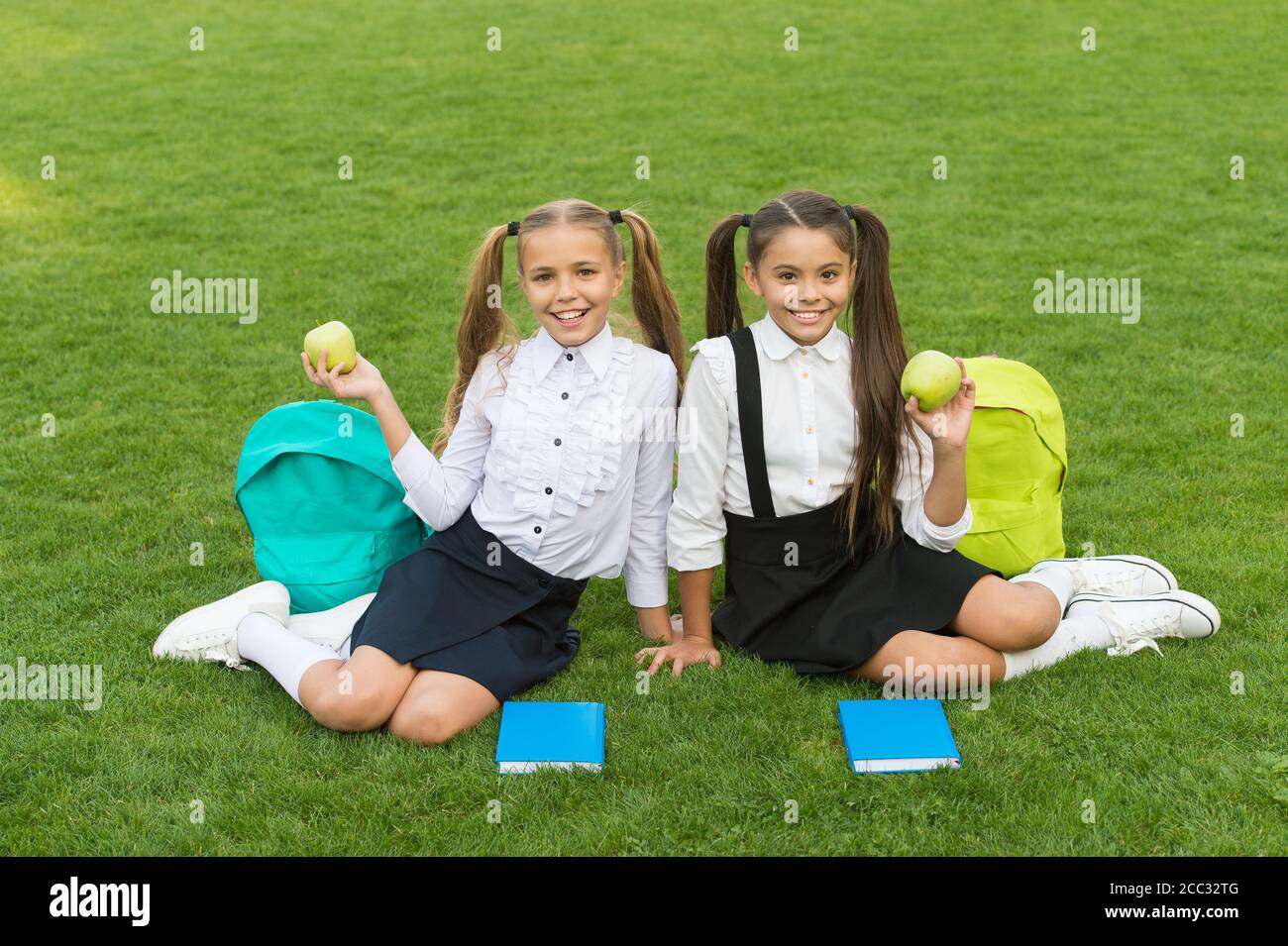 School friends relaxing after classes at school yard, lunch time ...