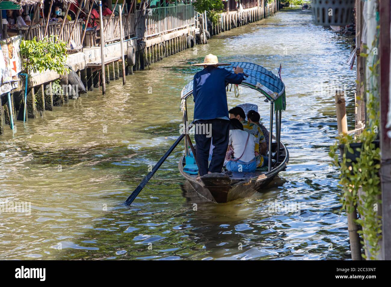 A man drive a gondola boat with tourist in a water canal at the Khlong ...