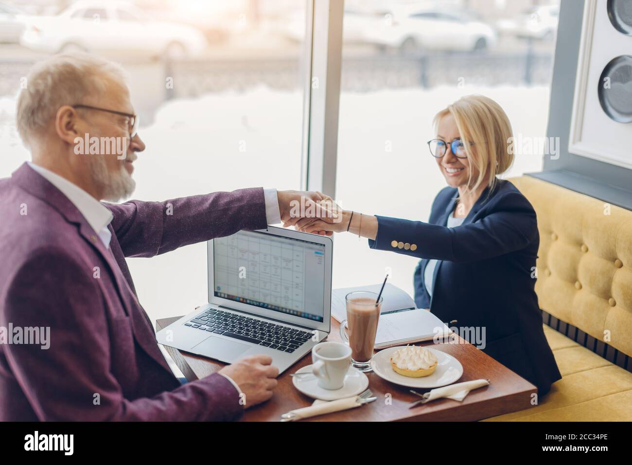 two business partners completing an agreement in the coffee shop. close ...