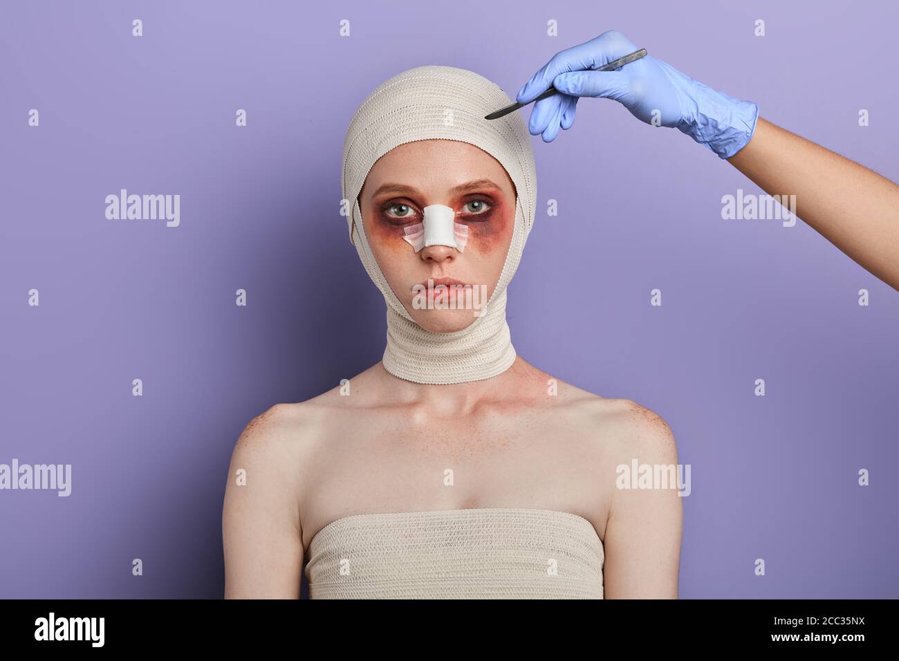 doctor in gloves holding scalpel near injured girl with bandages over ...