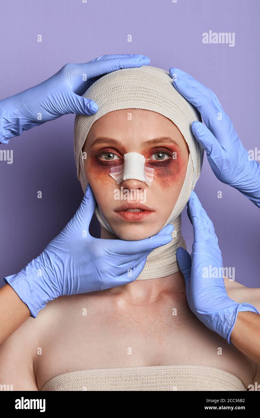 doctors in gloves touching their patient's face,checking it, preparing ...