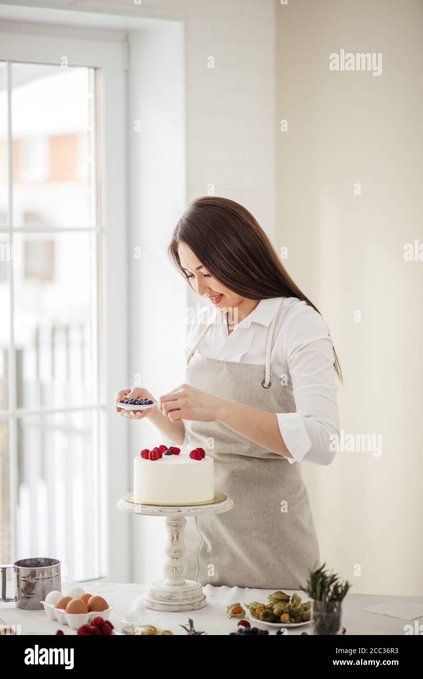 woman making bright and beautiful dessert for clients, customers. close ...