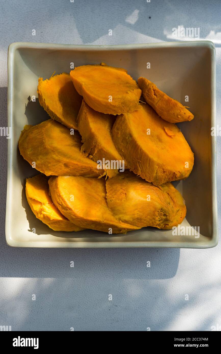 Top view of cooked and sliced red sweet potato. Camote close up on a ...