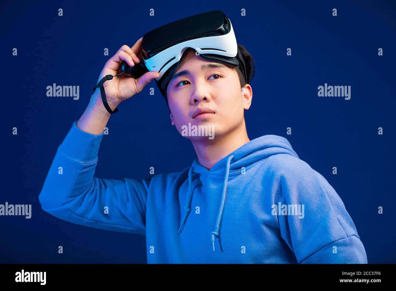 Successful Asian male virtual reality gamer taking off vr headset and ...