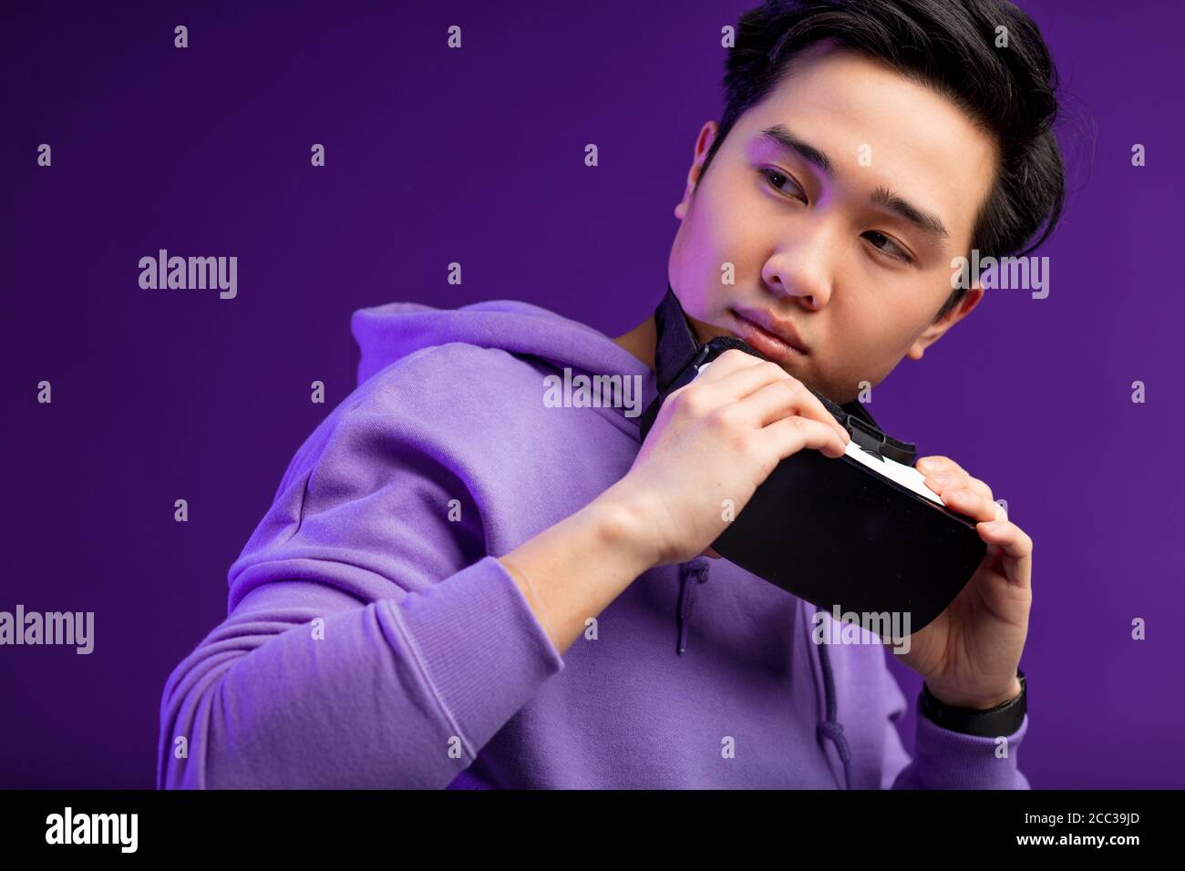 Successful Asian male virtual reality gamer taking off vr headset and ...