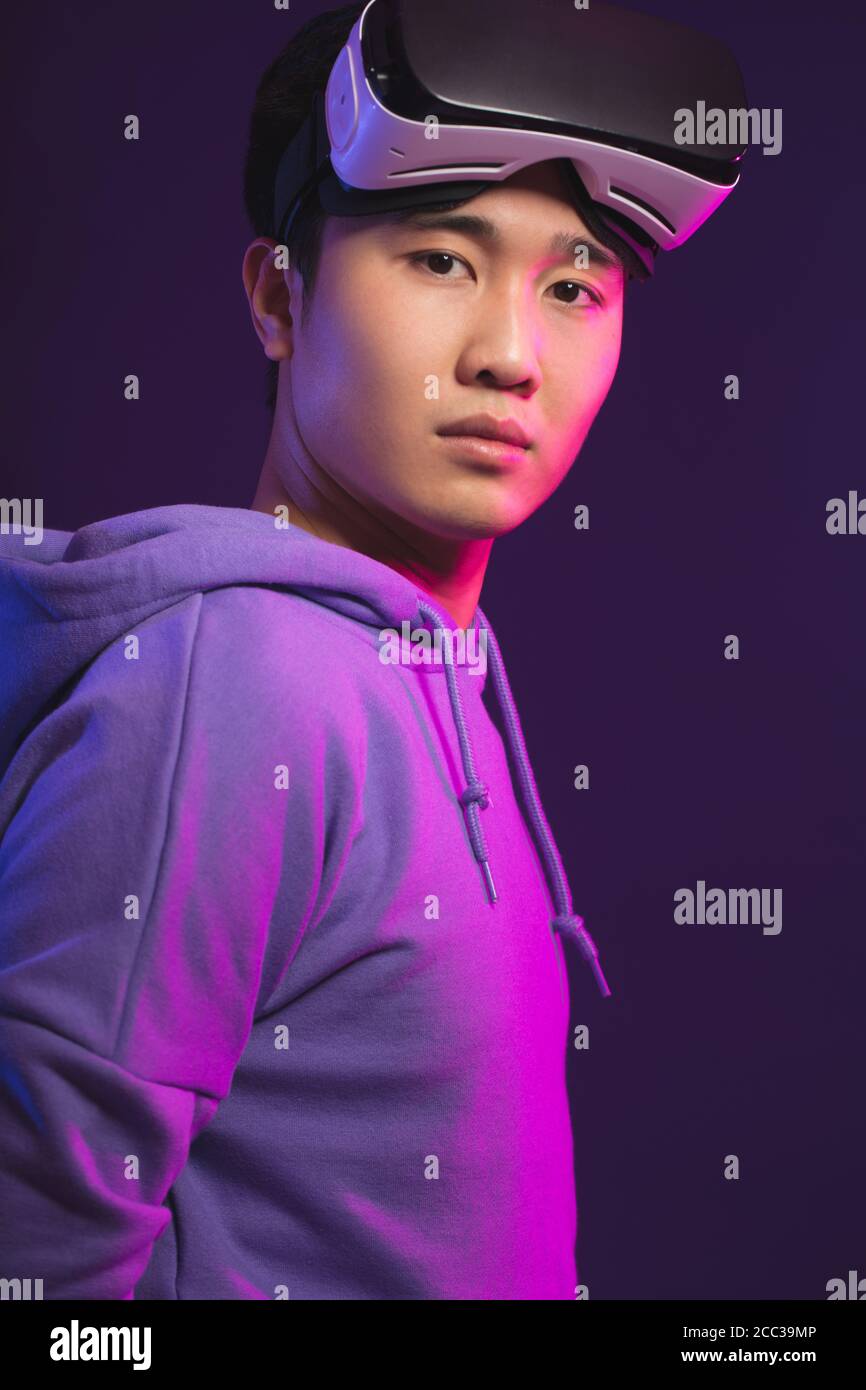 Successful Asian male virtual reality gamer taking off vr headset and ...